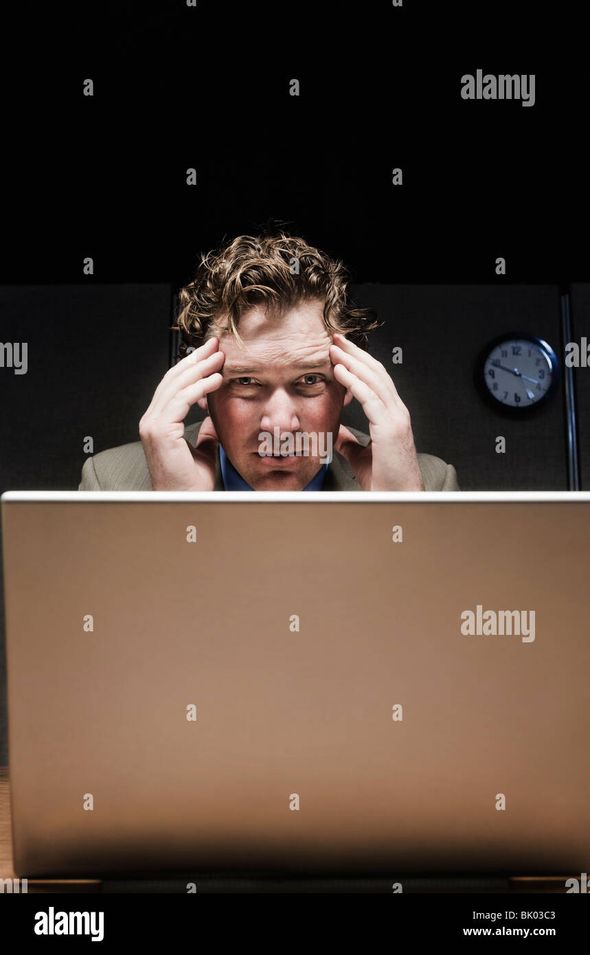 Man at computer looking stressed Stock Photo - Alamy