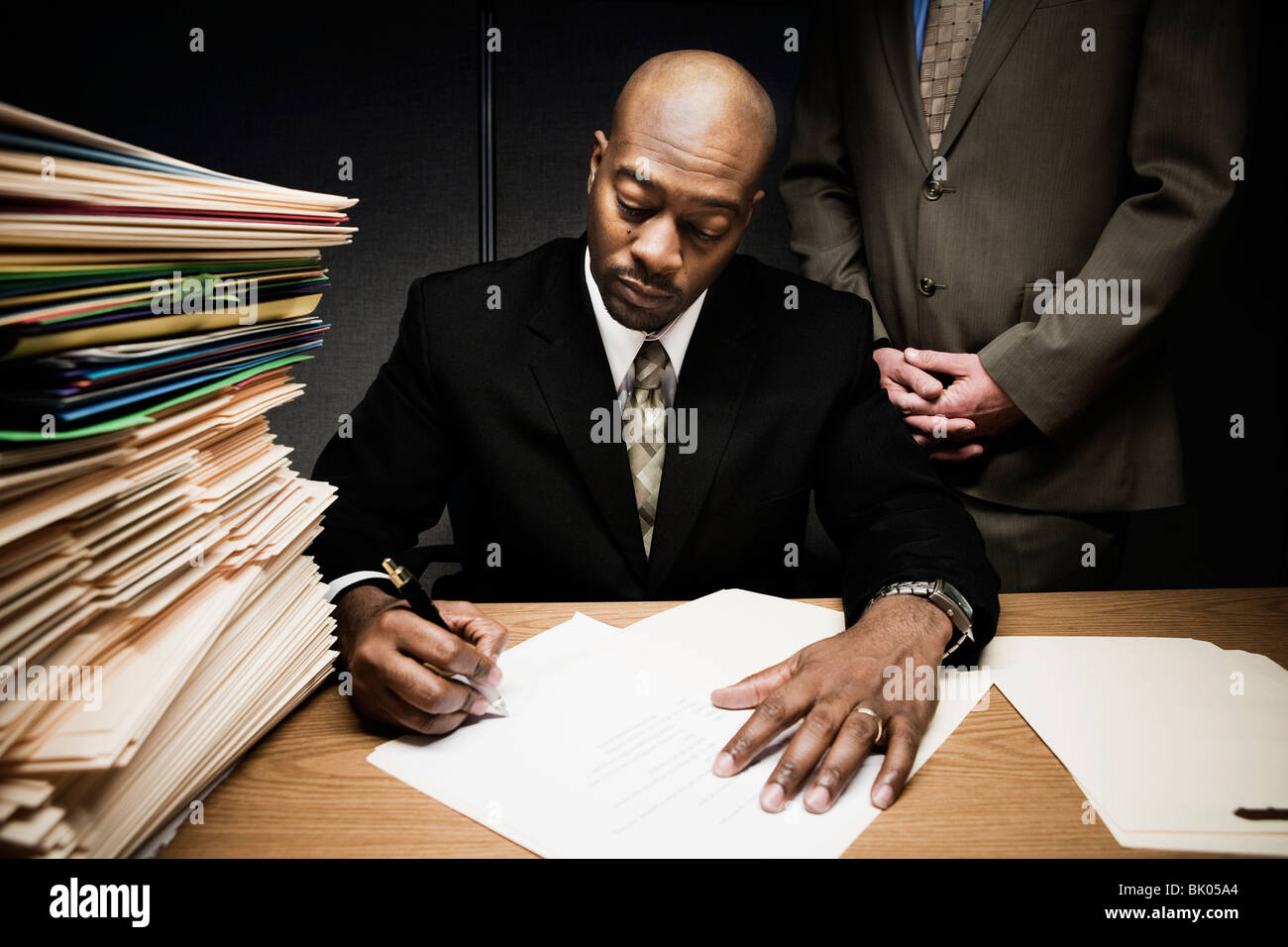 Man doing paperwork with man behind him Stock Photo - Alamy