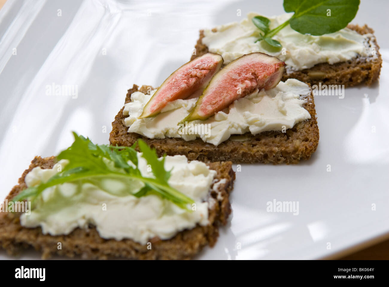 Pumpernickel rye bread canapes on a white plate Stock Photo - Alamy