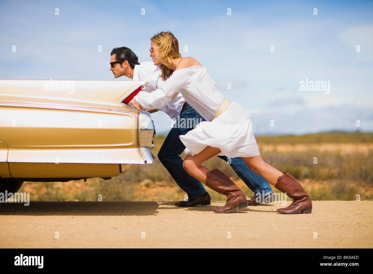 Couple pushing a car Stock Photo - Alamy
