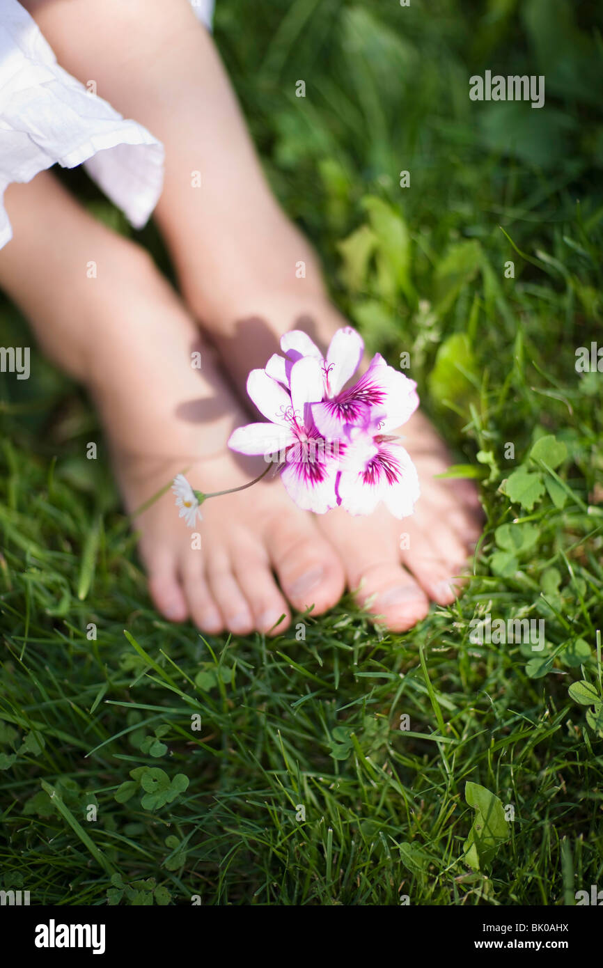 Childrens feet with a flower Stock Photo - Alamy
