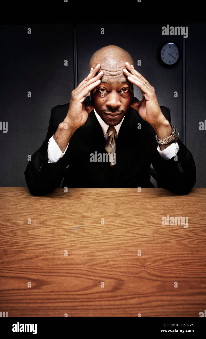 Business man at desk with hands on head Stock Photo - Alamy