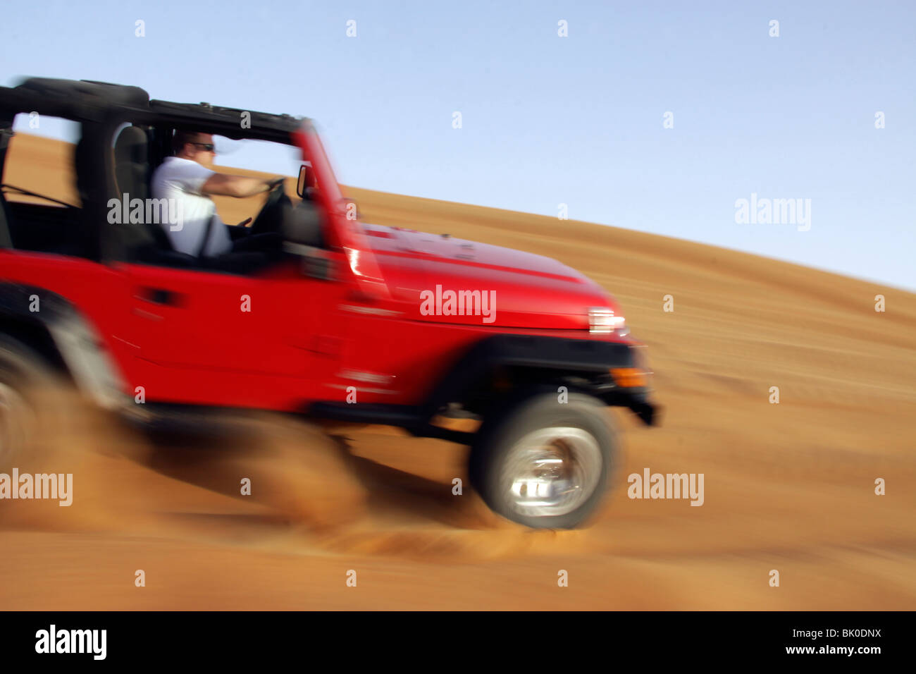 Jeep driving across the desert in Dubai, UAE Stock Photo - Alamy