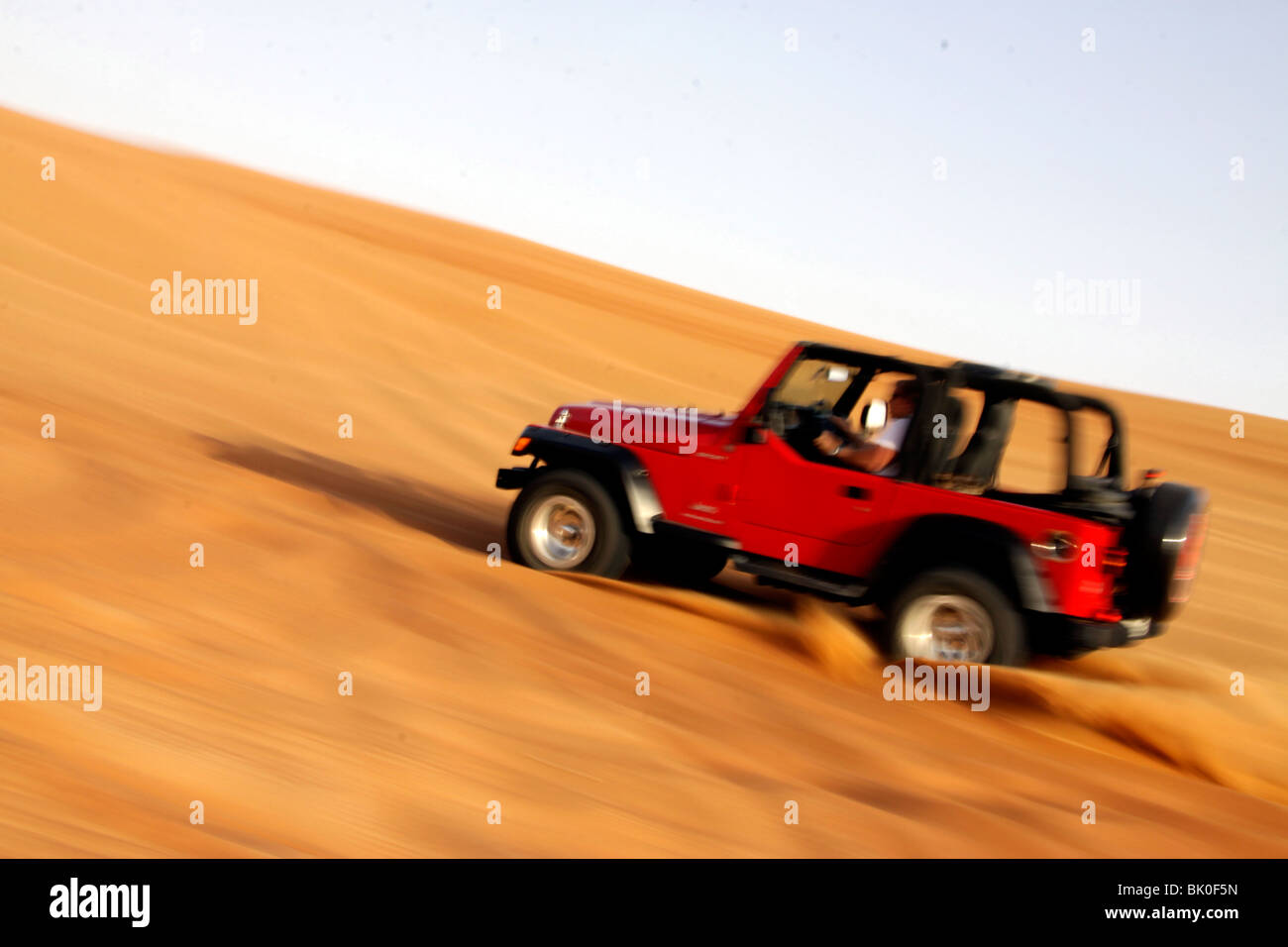 Jeep driving across the desert in Dubai, UAE Stock Photo - Alamy