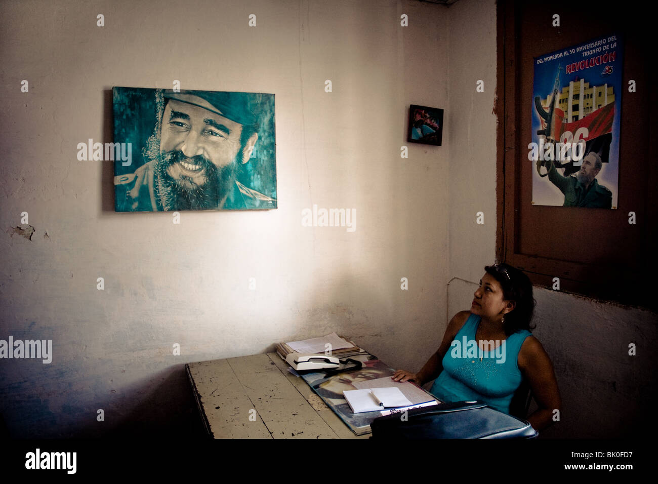 A Cuban office worker watching a painted portrait of the Cuban ...
