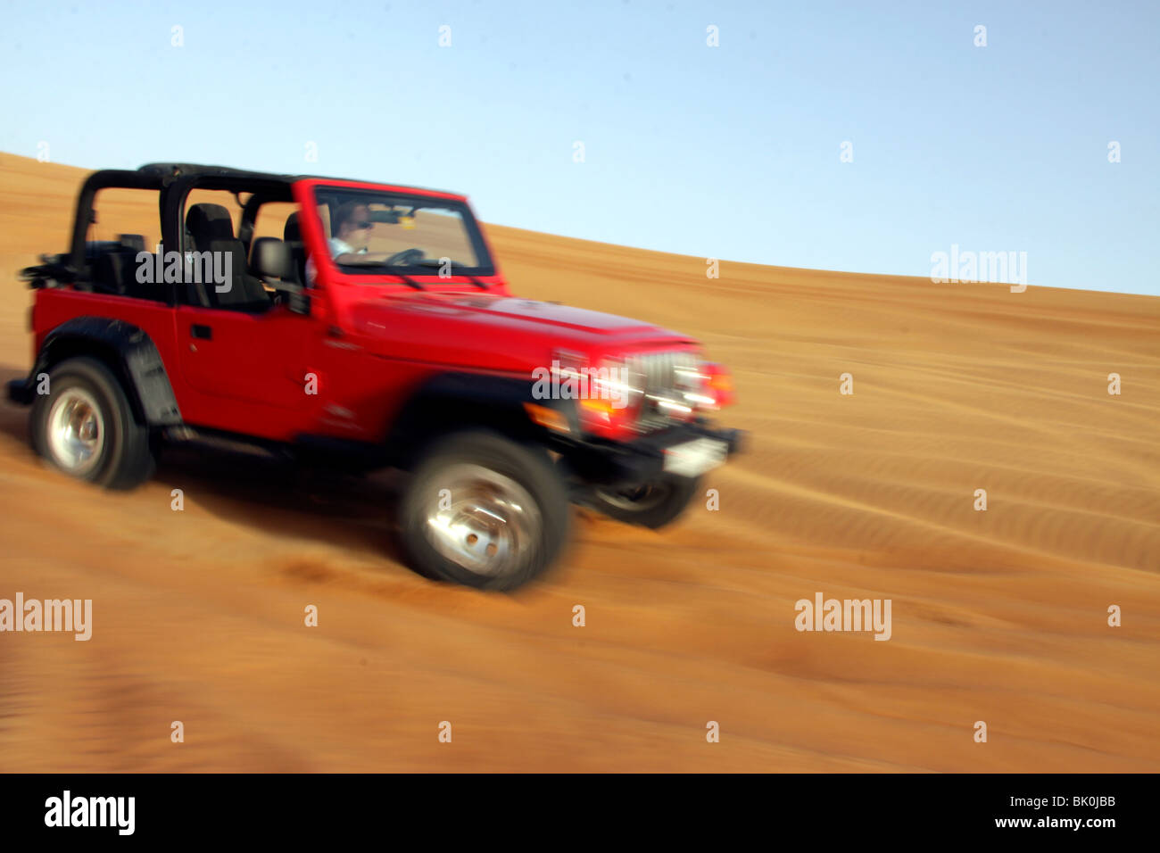Jeep driving across the desert in Dubai, UAE Stock Photo - Alamy