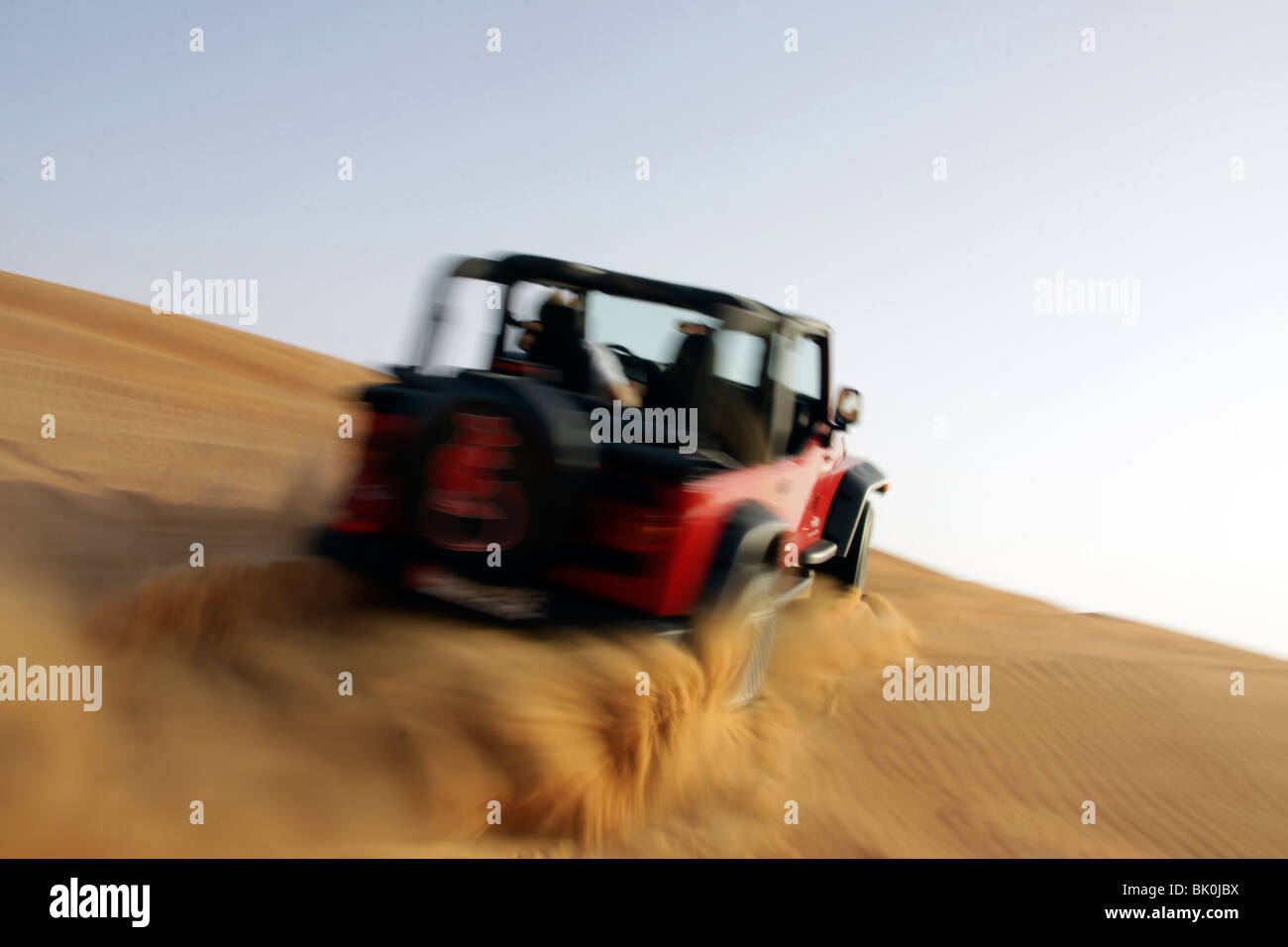 Jeep driving across the desert in Dubai, UAE Stock Photo - Alamy