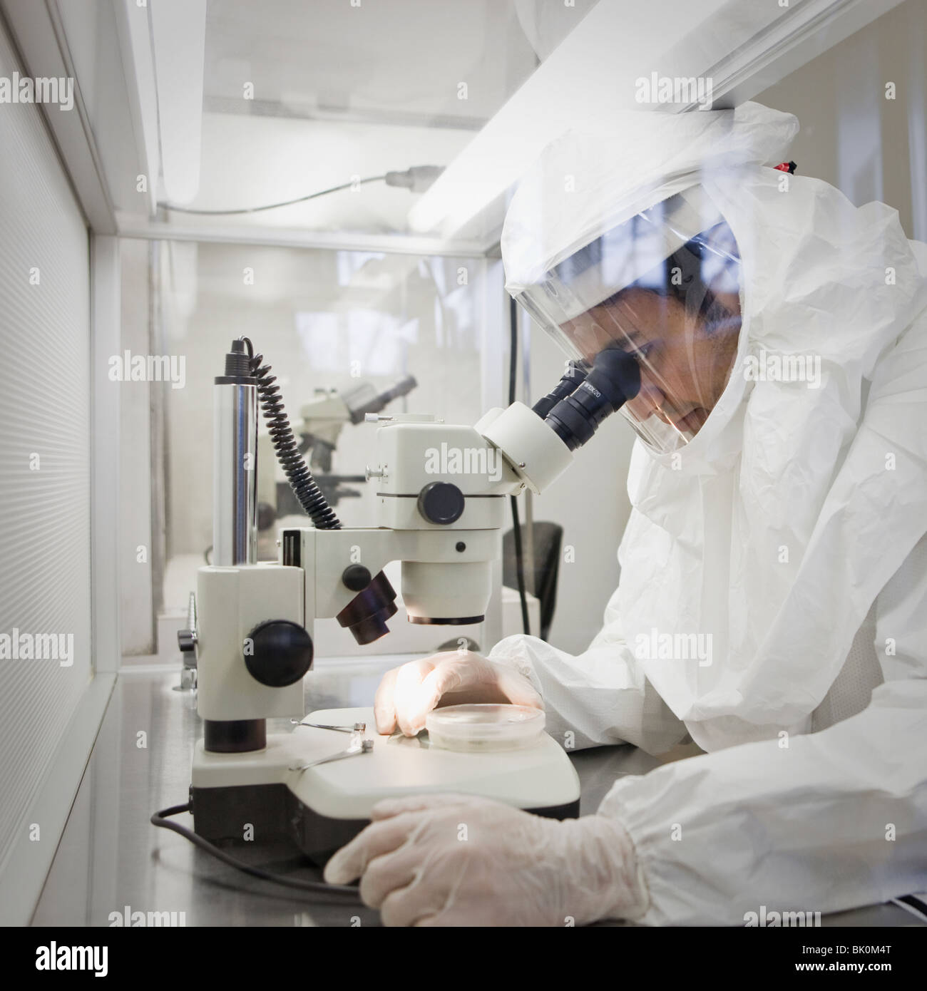 Middle Eastern scientist in clean suit using microscope Stock Photo - Alamy