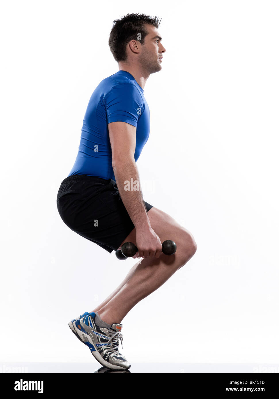 man doing workout squats weight training crouching on studio white ...