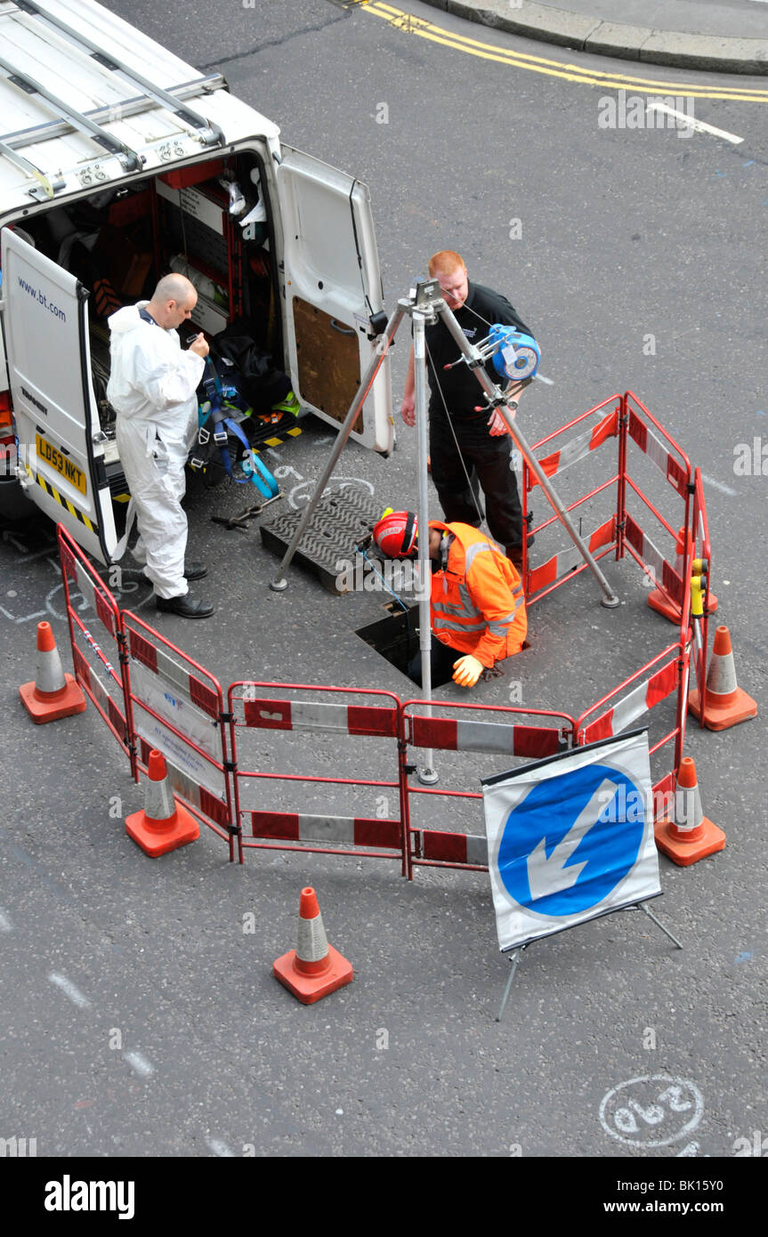 BT telephone engineers working in street and accessing underground ...