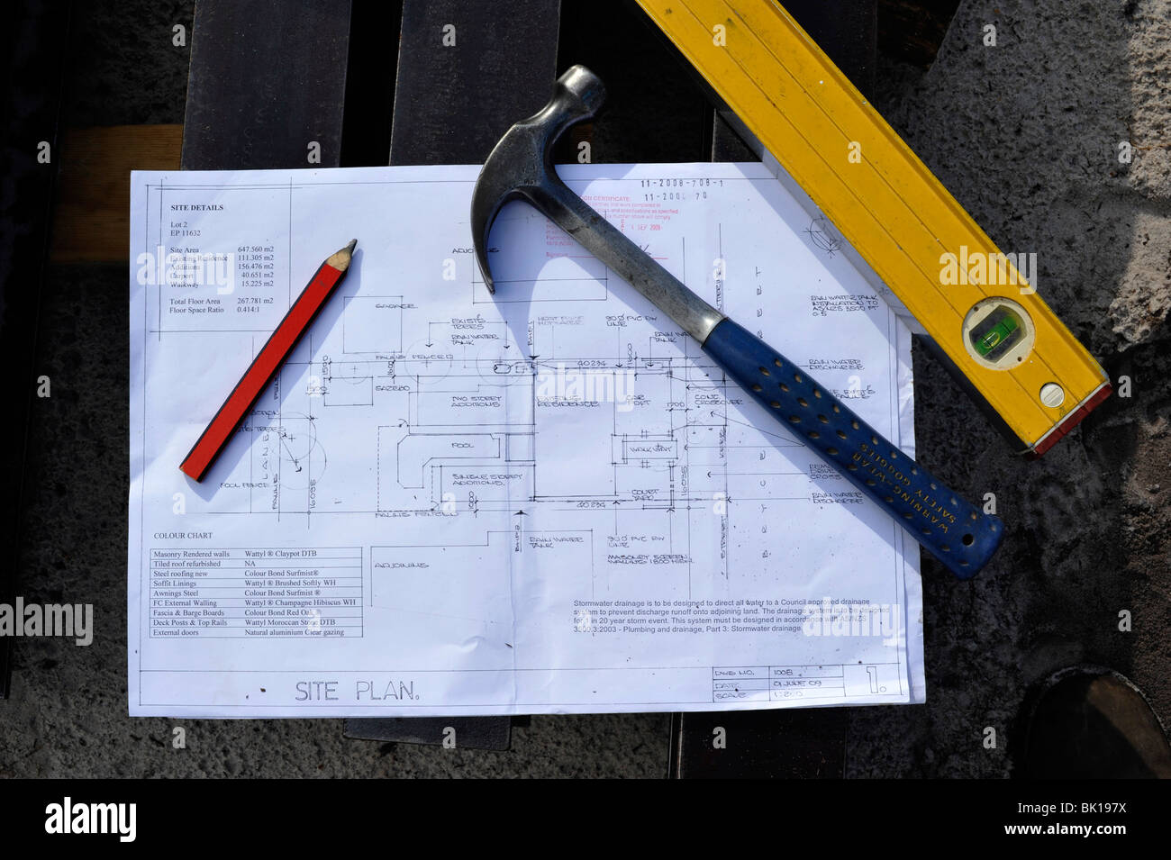 Construction site plans with hammer pencil and level Stock Photo - Alamy