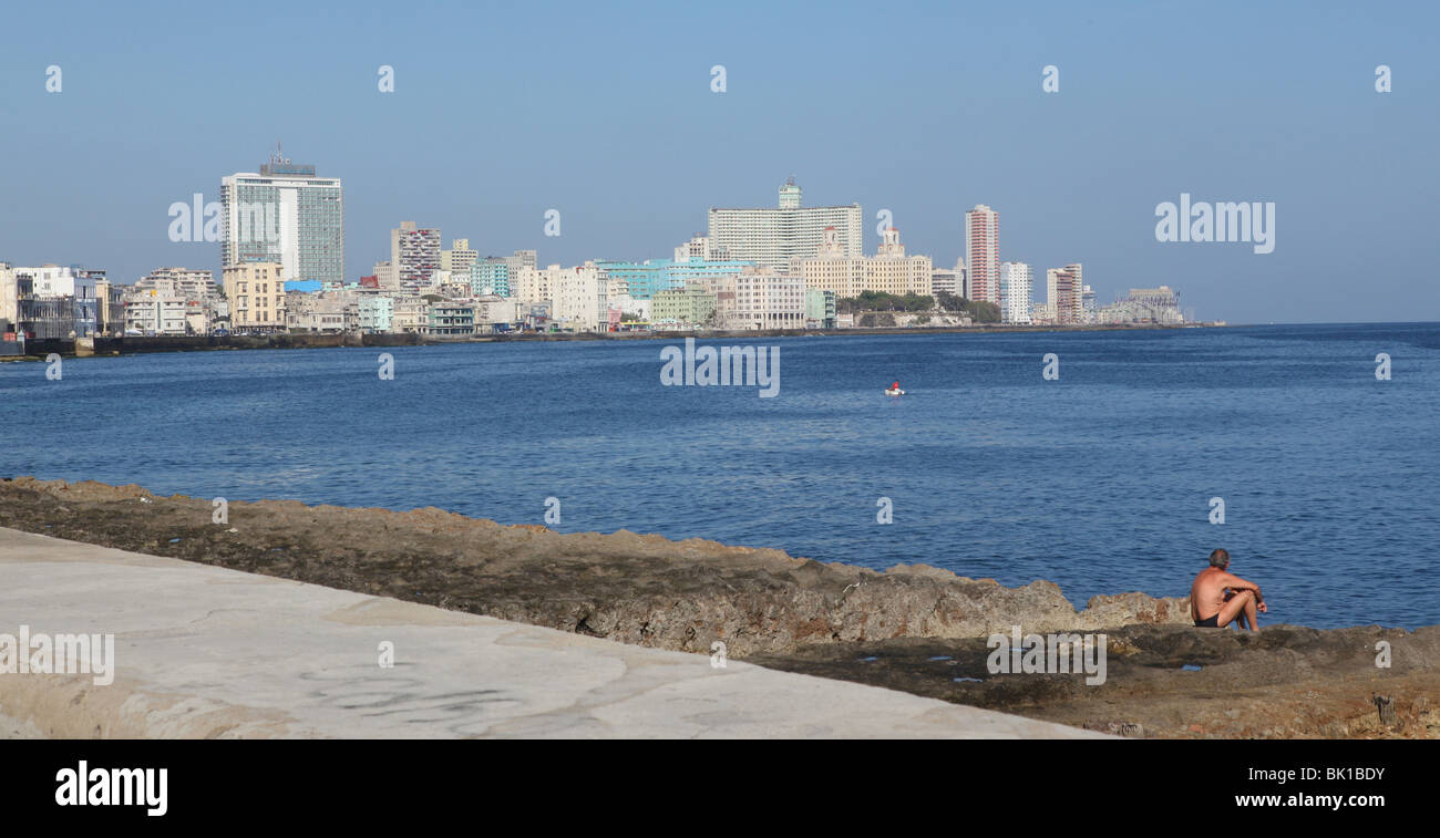 A swimmer looks out over the sea just off the Malecon, Havana Cuba ...
