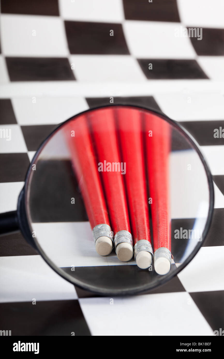 Pencils through a magnifying lens on a chessboard background Stock ...