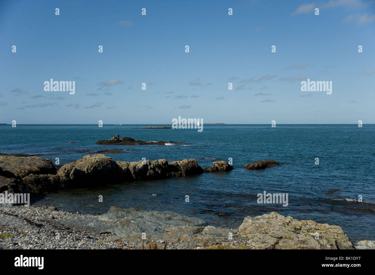 Skerries Lighthouse and fisherman from the Anglesey coastal footpath ...