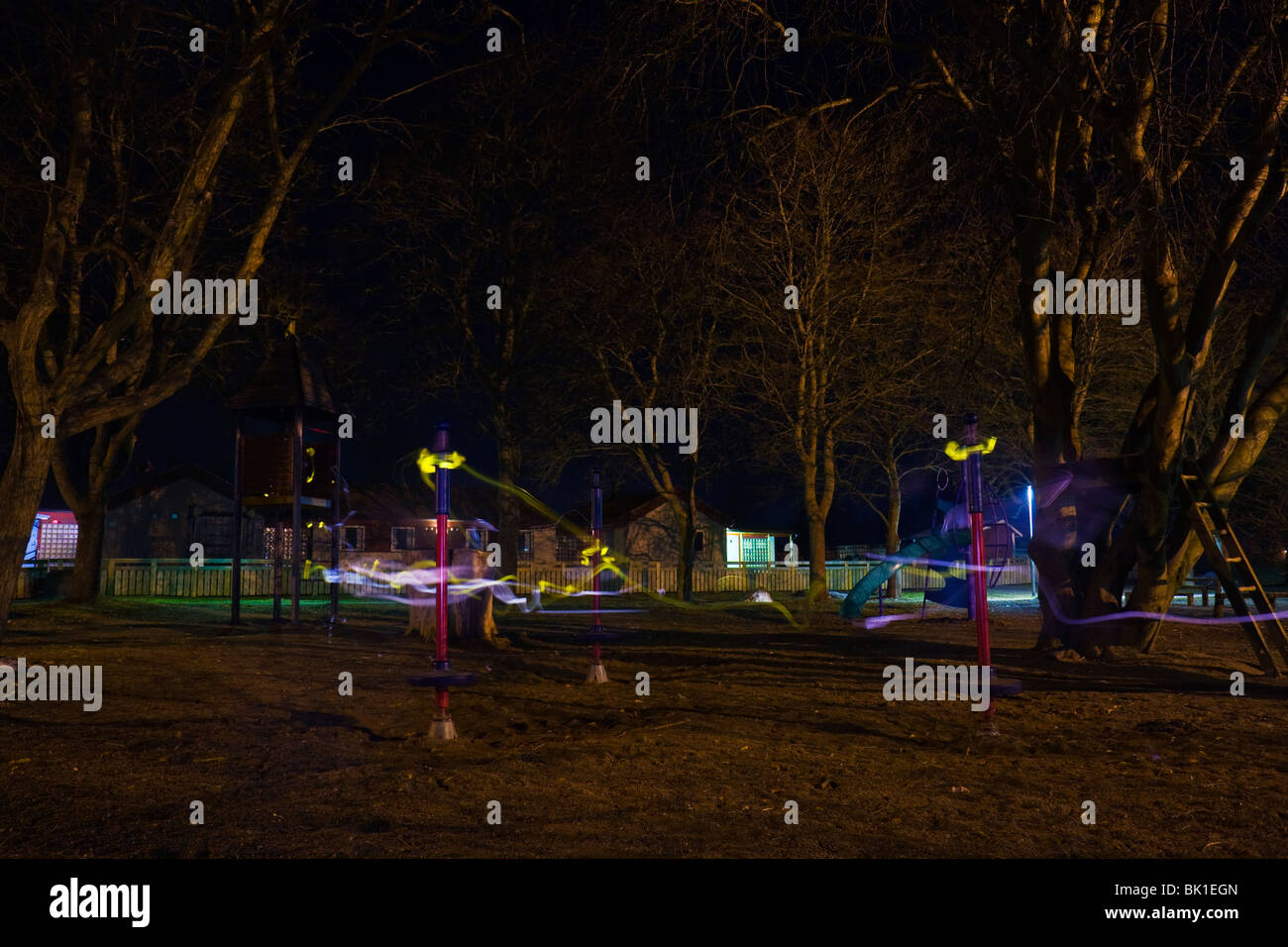 Light trails from reflexes of a child on a playground by night, long ...