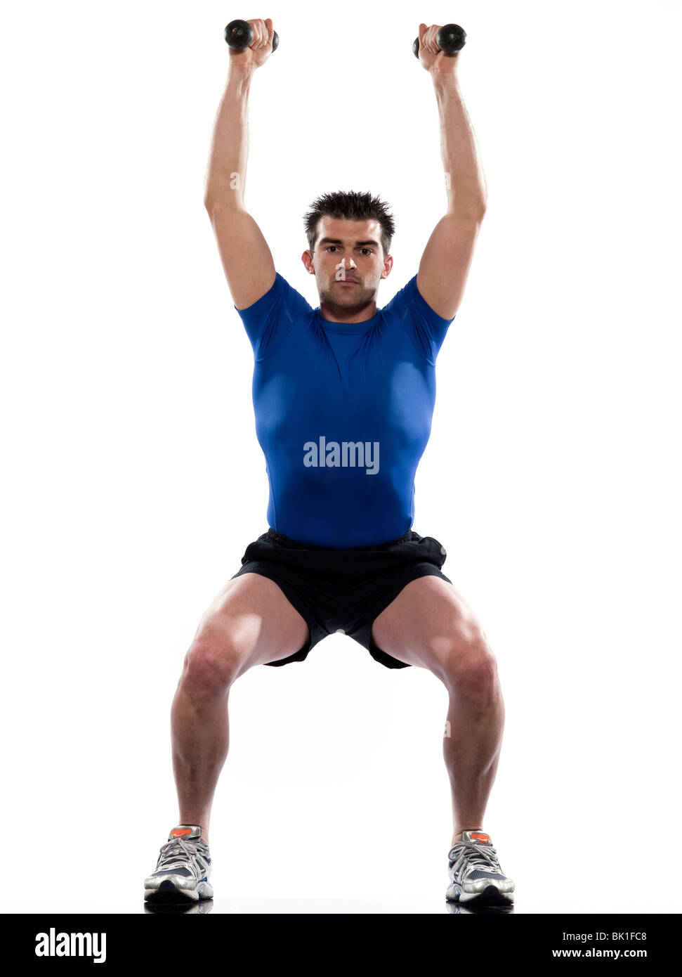 man doing workout squats weight training crouching on studio white ...
