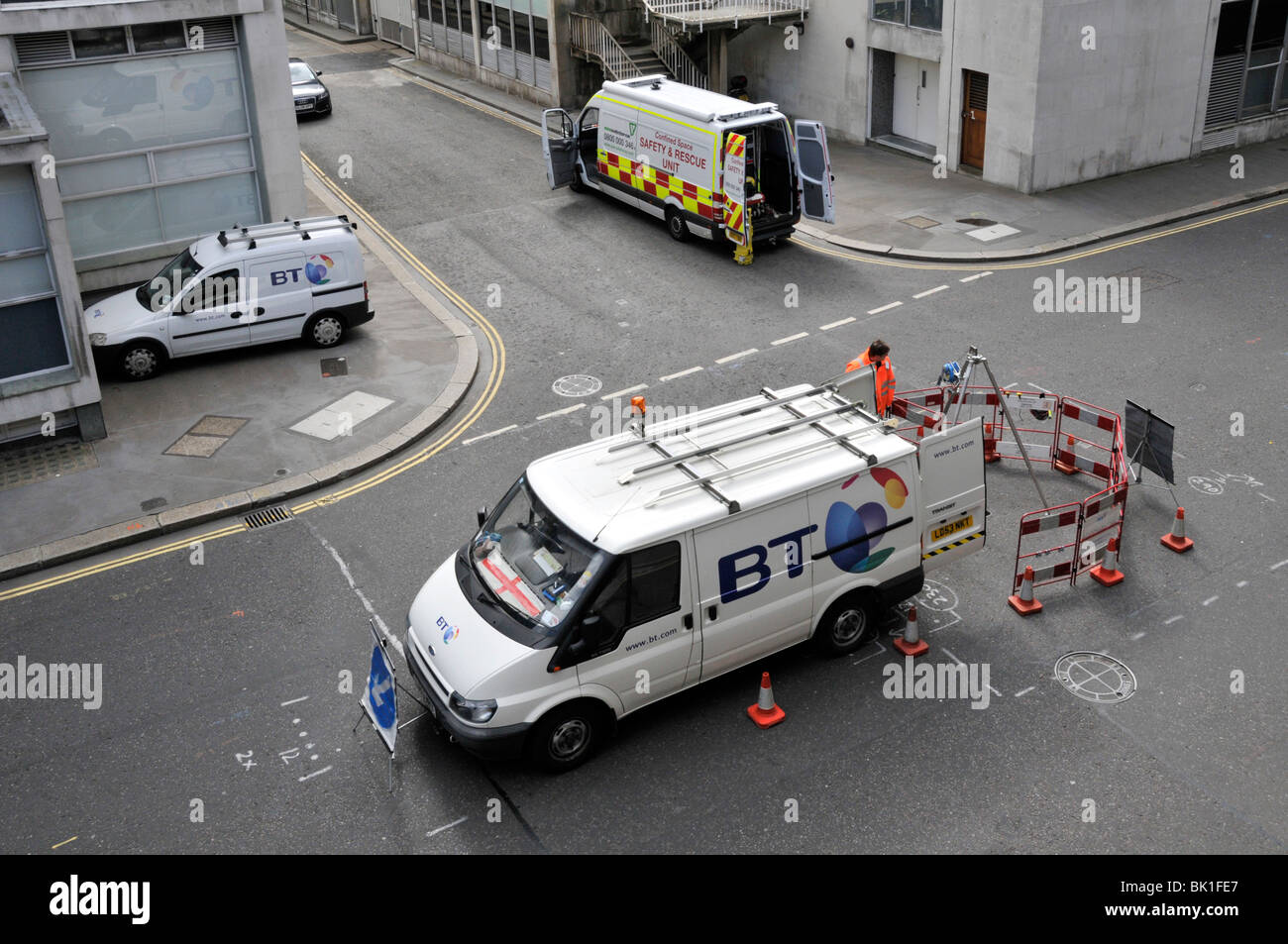 BT telephone engineer working in street and accessing underground ...