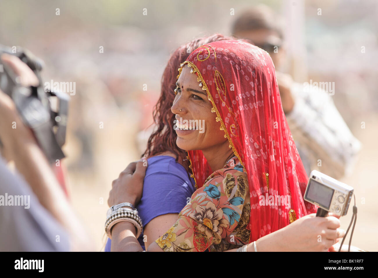 Indian and a foreigner lady greeting each other at Pushkar camel race ...