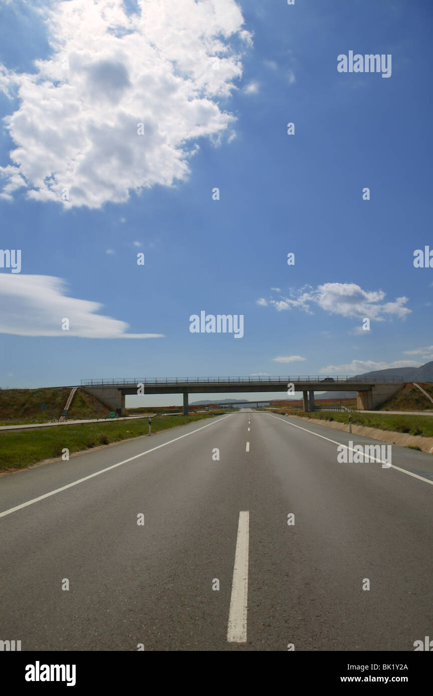 Bridge and road horizon front perspective view in a sunny blue sky ...