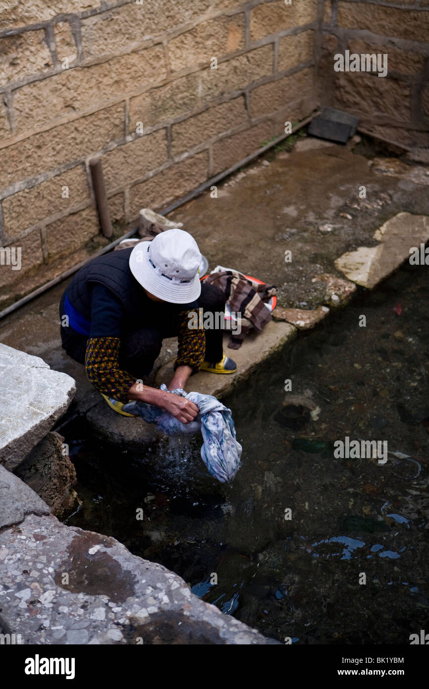 Local woman washing clothes in a stream. Lijiang, Yunnan, China Stock ...