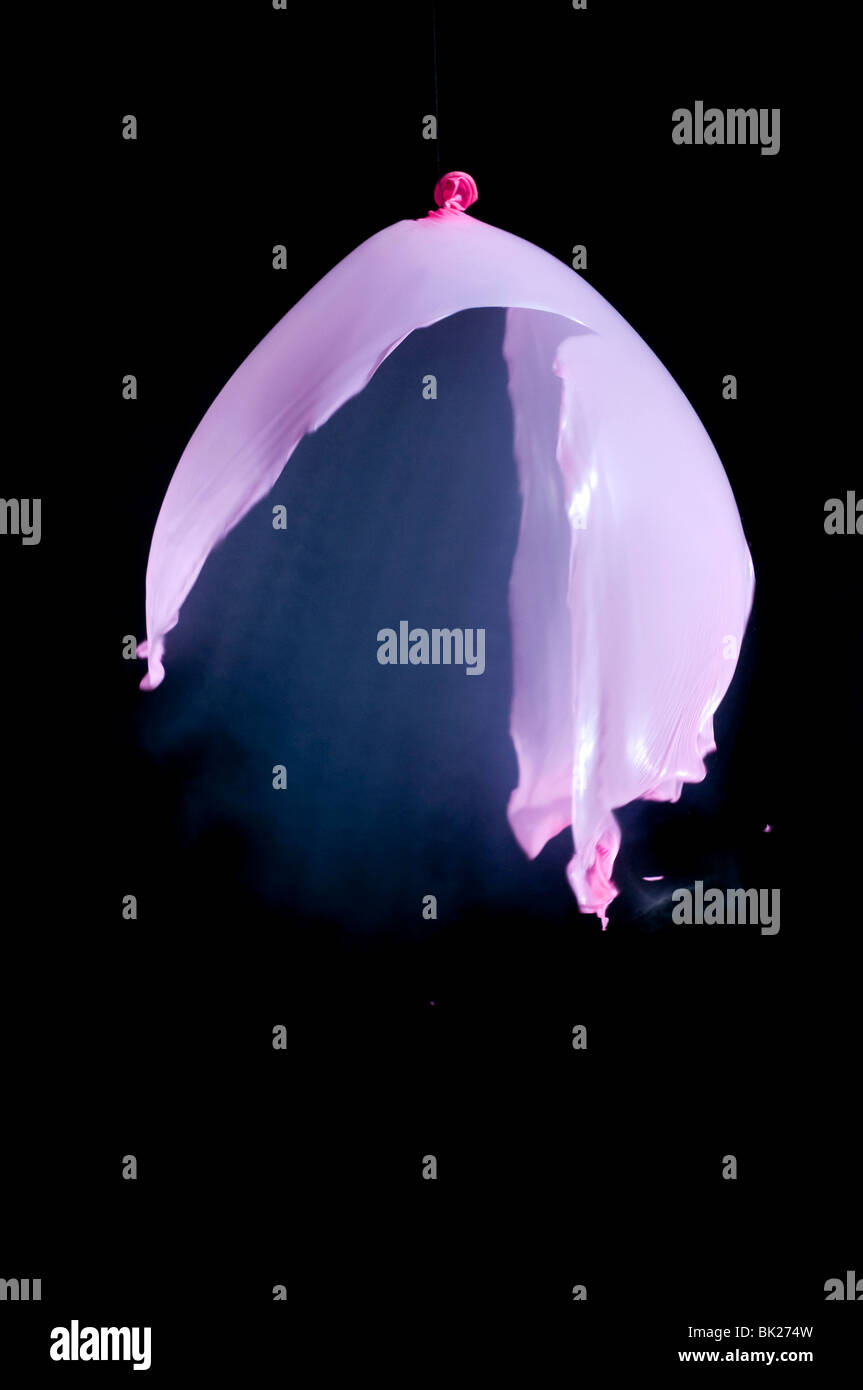 A smoke filled pink balloon bursting when shot with an air rifle. Sound ...
