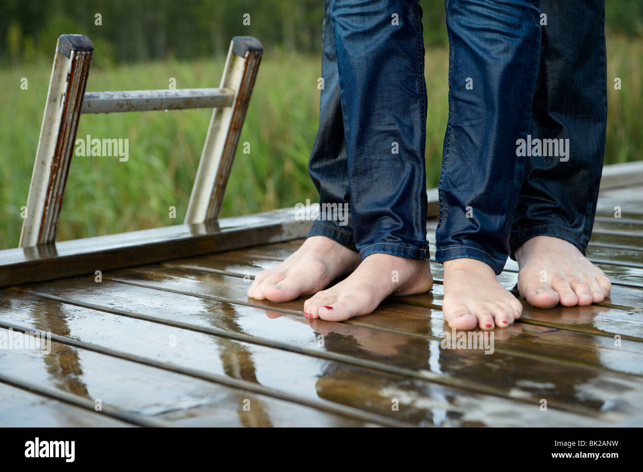 Wet feet of a couple on a dock Stock Photo - Alamy
