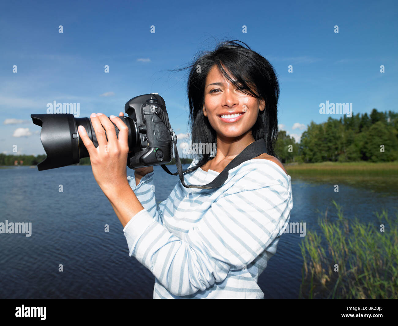 Woman taking pictures, smiling Stock Photo - Alamy