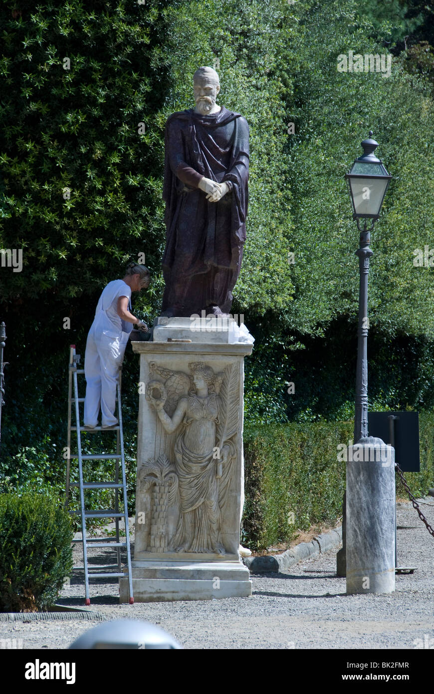 Man on a ladder cleaning and restoring a statue in Florence Italy Stock ...