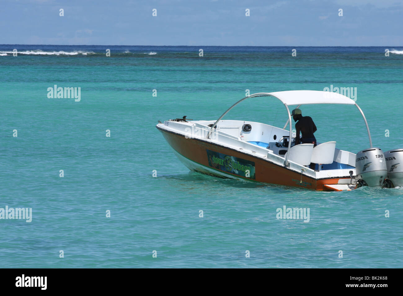 Man on motor boat tobago Stock Photo - Alamy