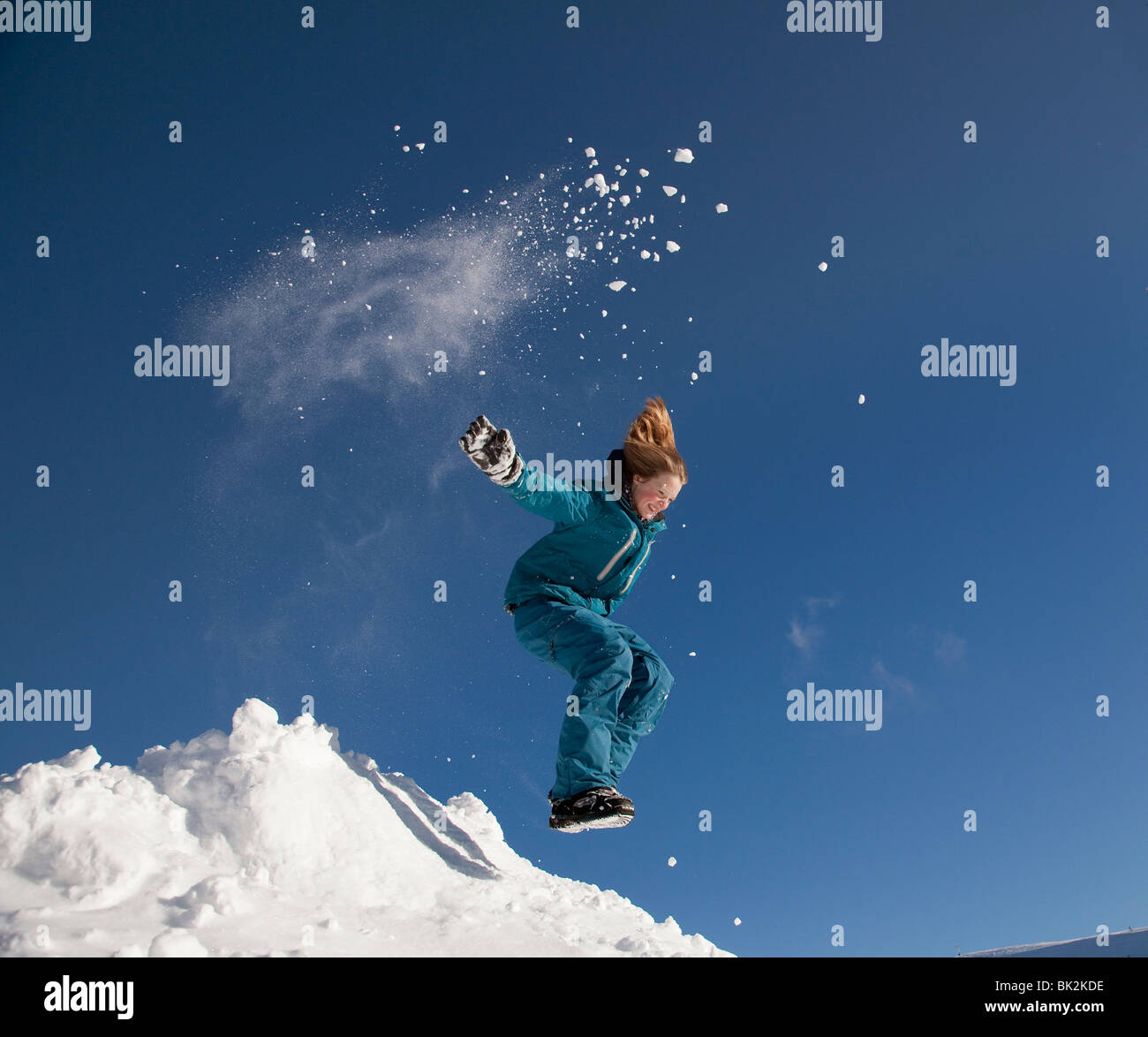 Girl jumping in snow Stock Photo - Alamy