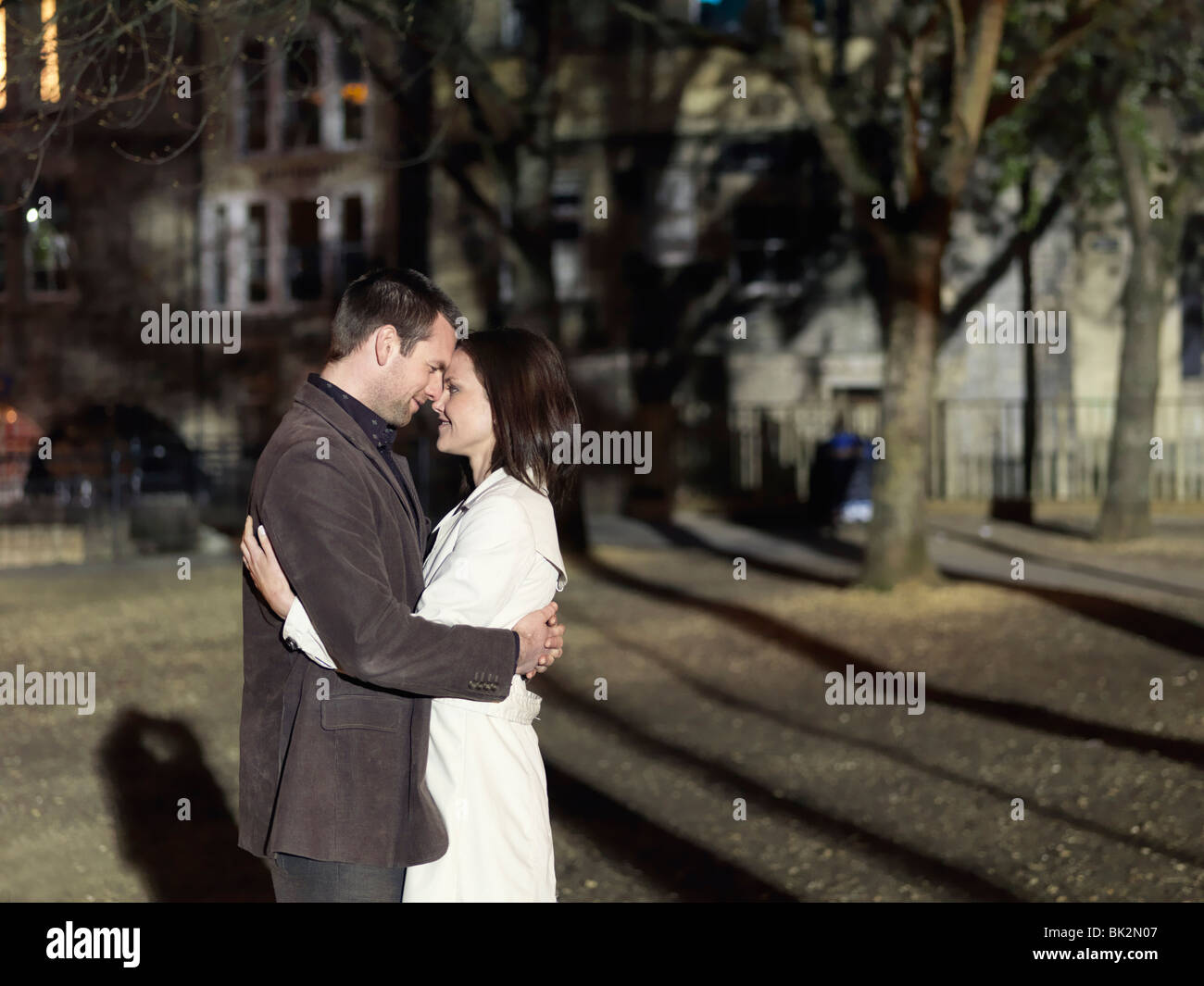 Couple hugging in park at night Stock Photo - Alamy