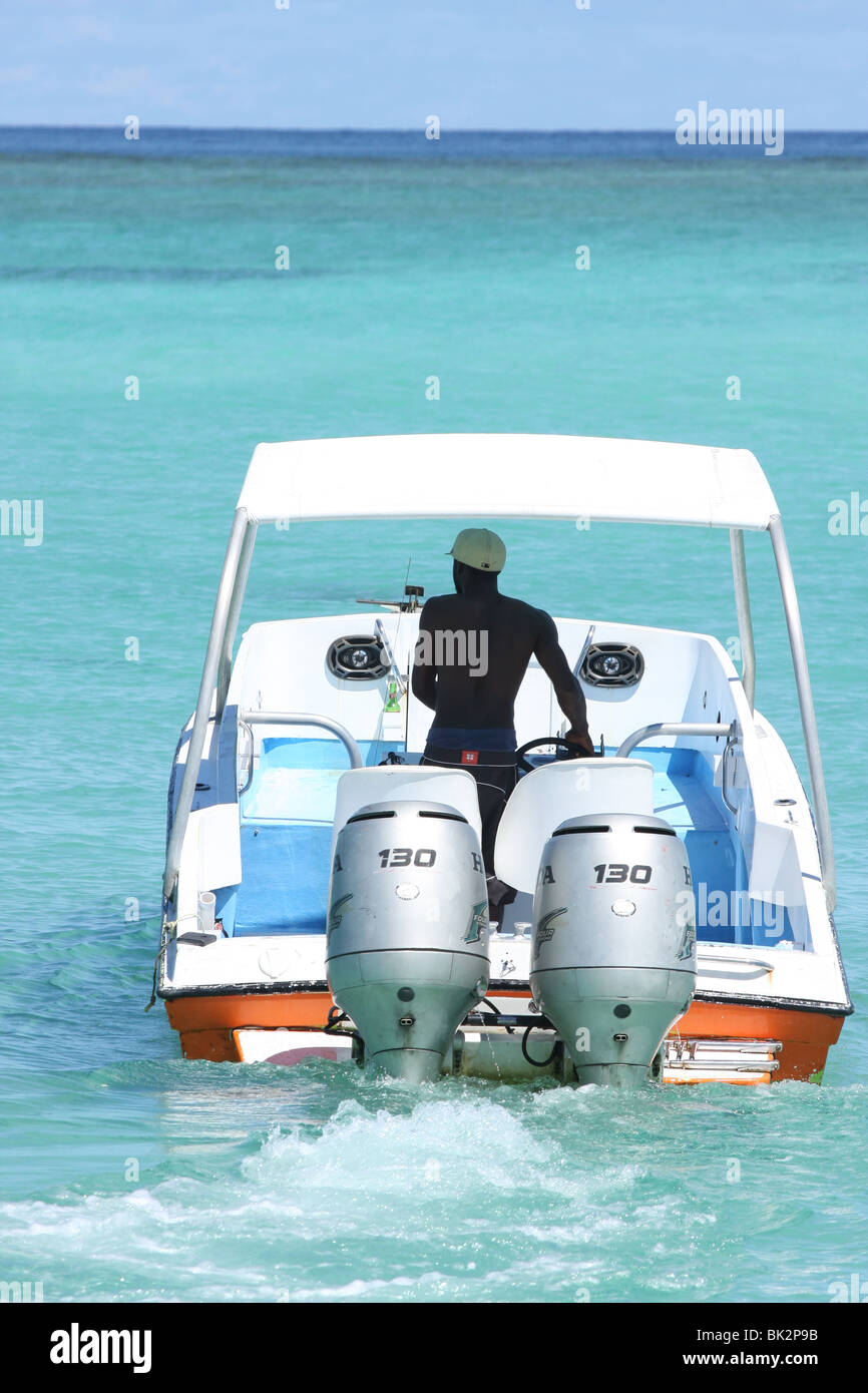 Man on motor boat tobago Stock Photo - Alamy