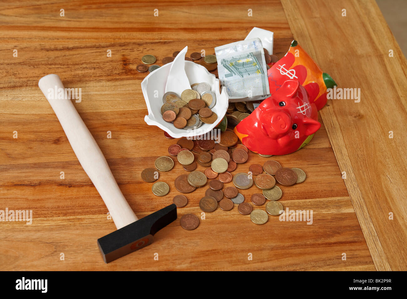 Smashed piggy bank with euros and hammer Stock Photo - Alamy