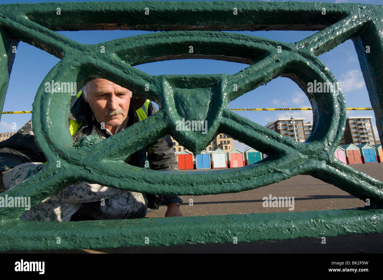 An older man painting the cast iron railings along the seafront ...
