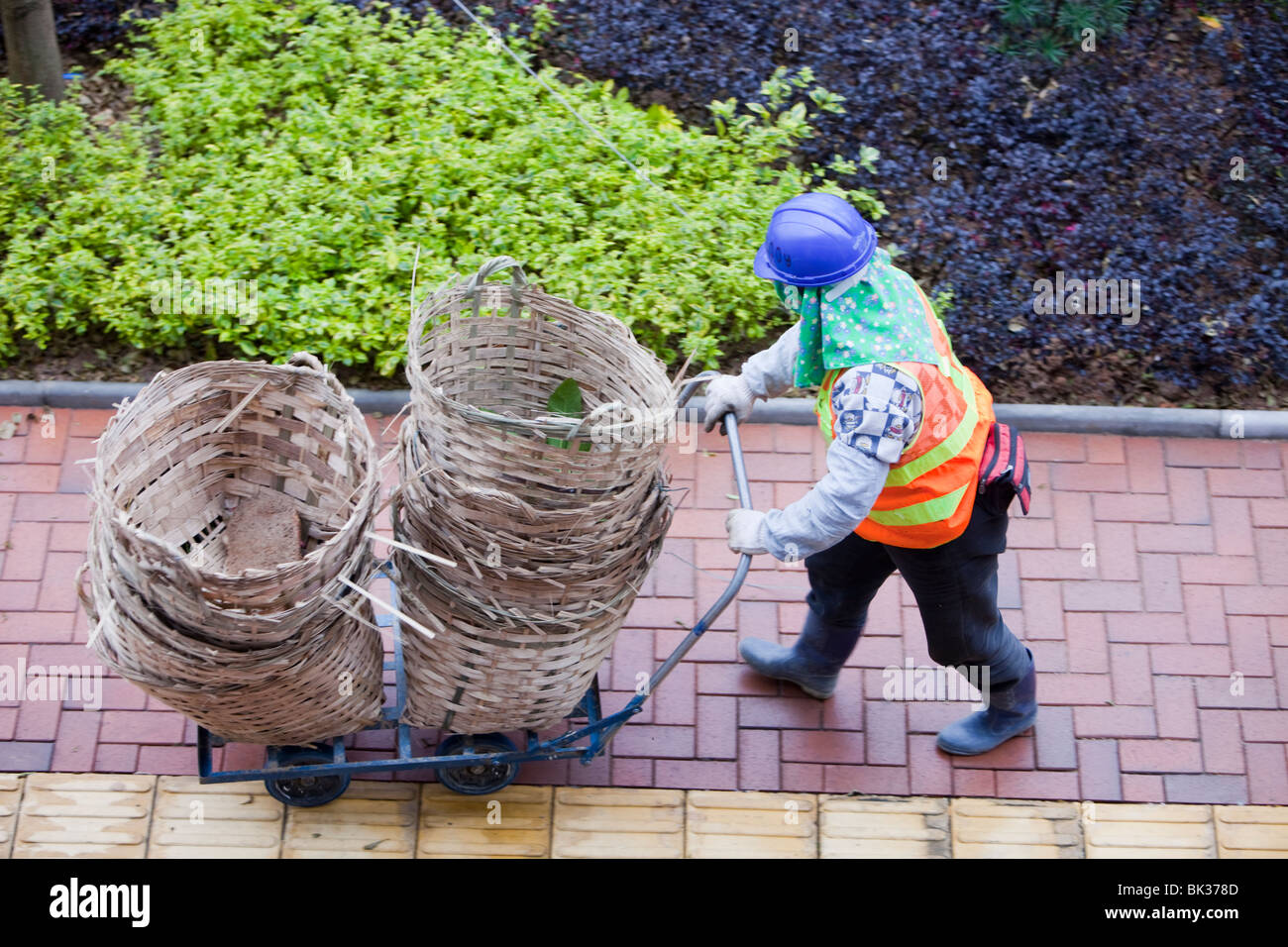 A workman on a building site in Hong Kong, China, pushing a trolley ...
