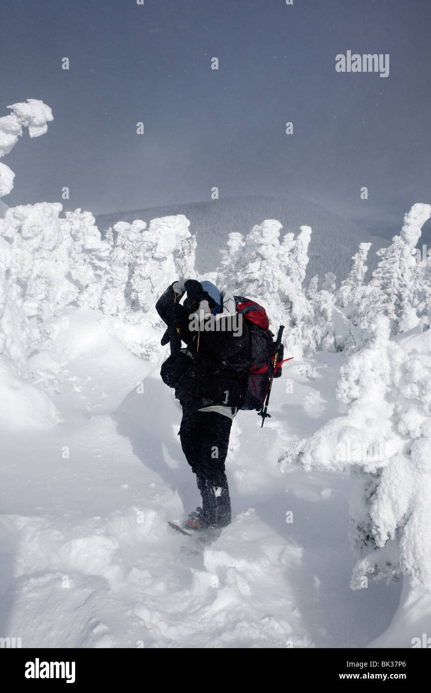 A hiker photographing along the Carter-Moriah Trail in winter ...