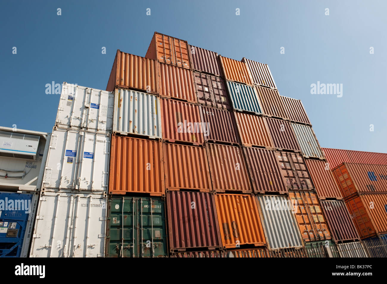 Shipping containers stacked up against blue sky Stock Photo - Alamy
