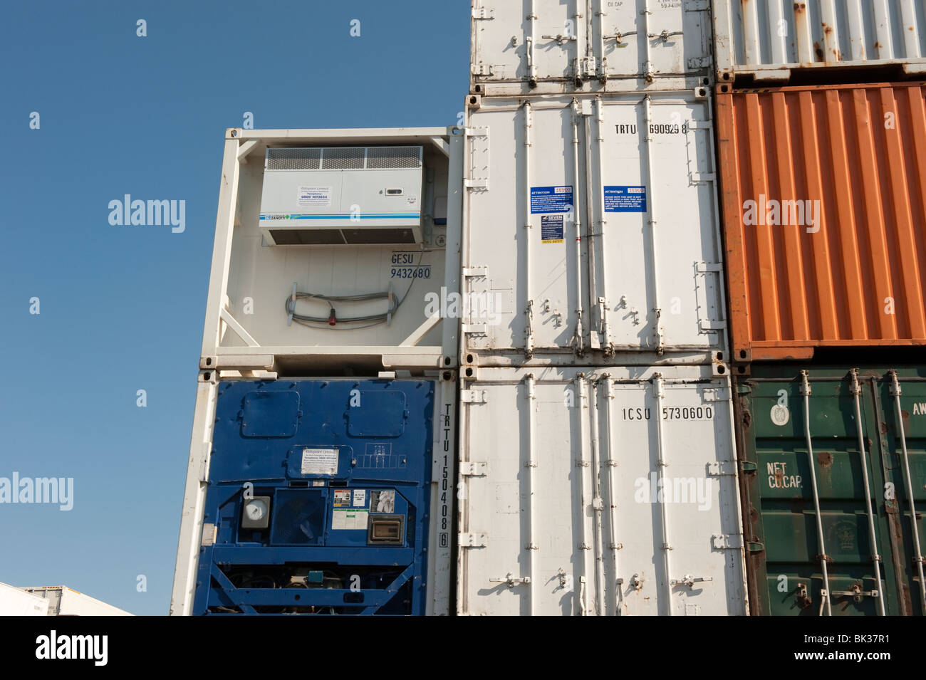 Shipping containers stacked up against blue sky Stock Photo - Alamy