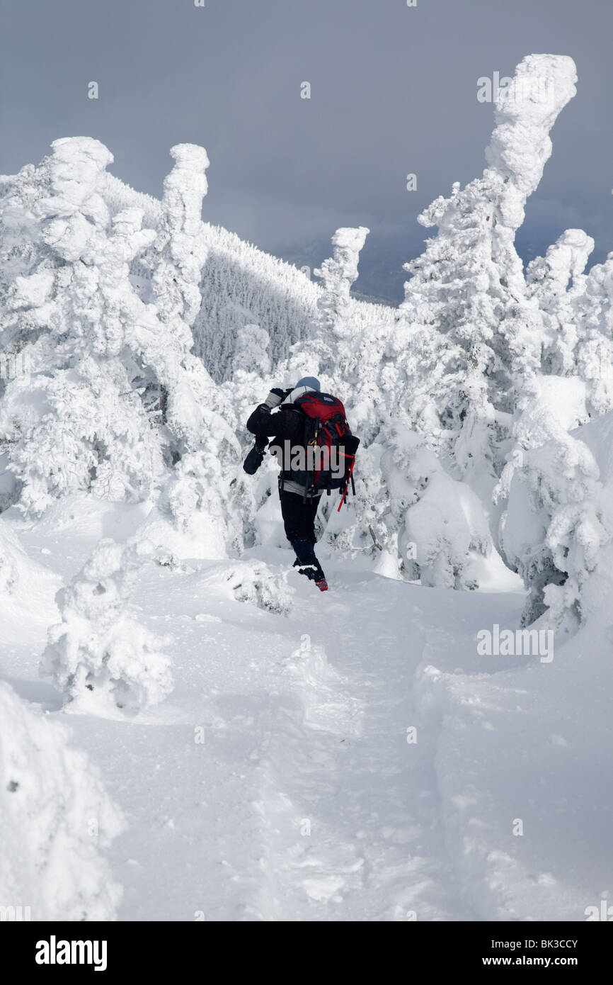 A hiker photographing along the Carter-Moriah Trail in winter ...