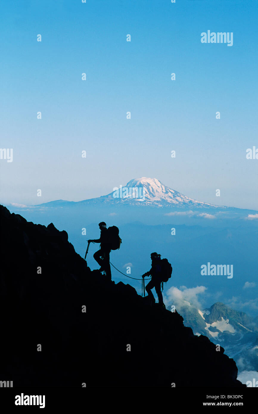Two climbers ascending Mount Rainier with Mount Adams on horizon, Mount ...