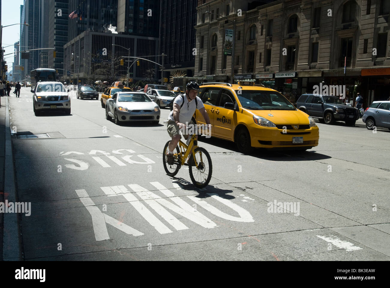 A bicyclist maneuvers through traffic in Midtown Manhattan in New York ...