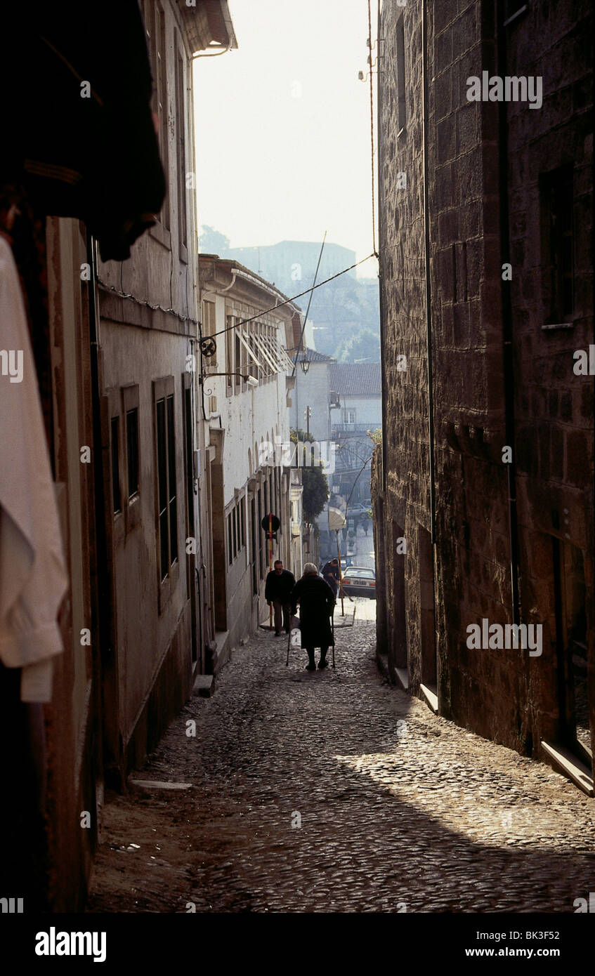 Narrow steep cobblestone walkway between historic buildings in Portugal ...
