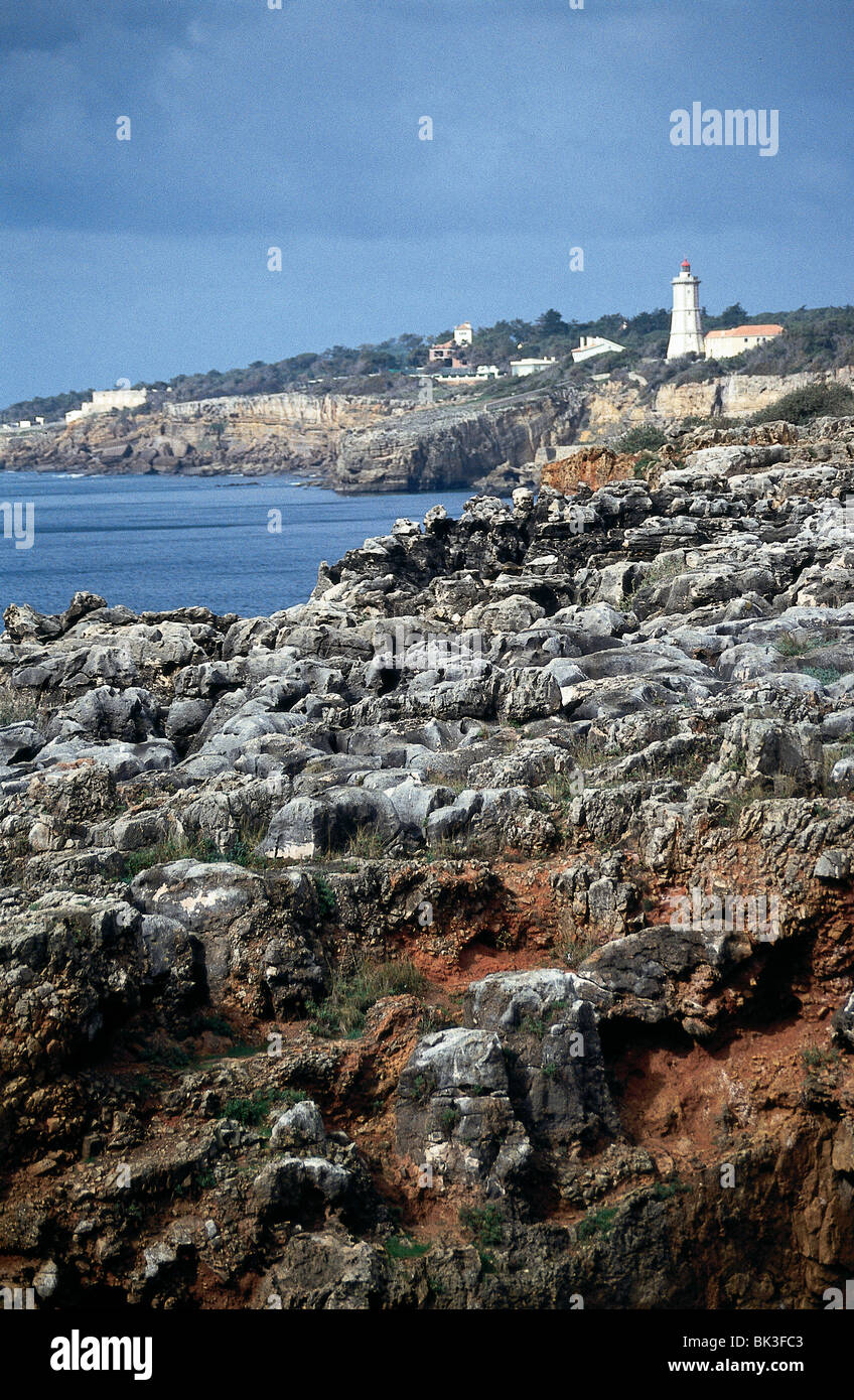 Coastal sandstone cliffs and lighthouse along the Atlantic Ocean coast at Cabo Espichel ...