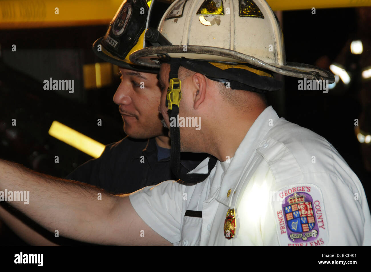 Two firefighters discuss strategy at the scene of a fire Stock Photo ...