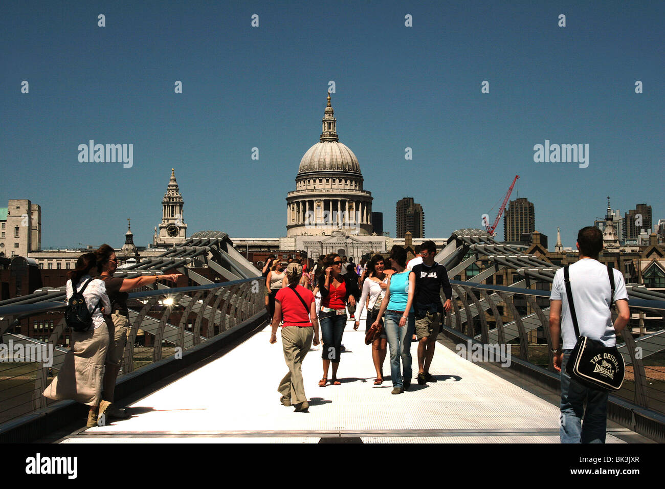 Tourists walking over the Millennium Bridge towards St Paul's Cathedral ...
