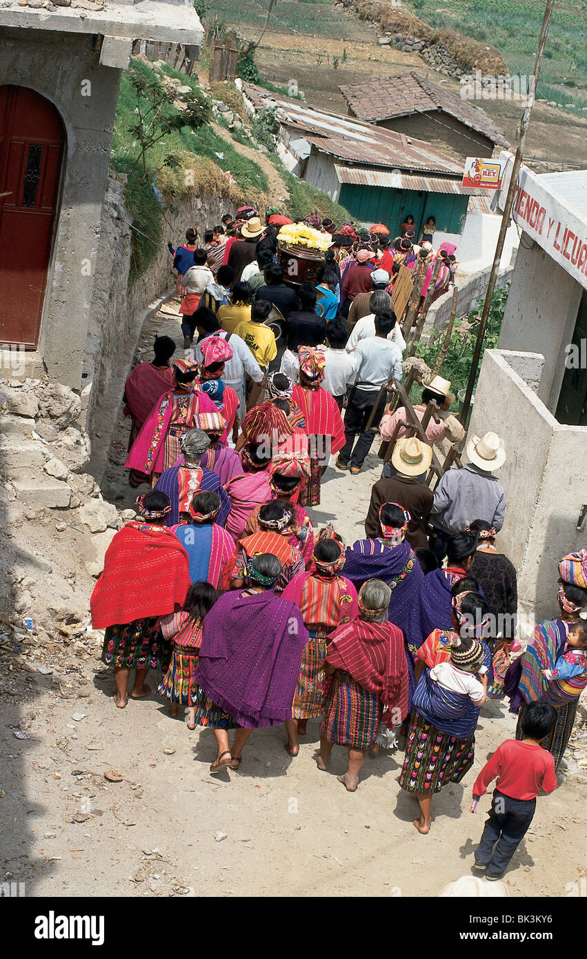 Indigenous people wearing traditional clothing carrying a coffin in a ...