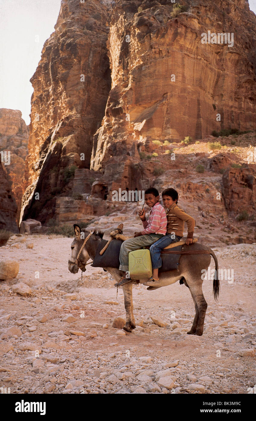 Portrait of two children sitting on a donkey at the Middle East ...