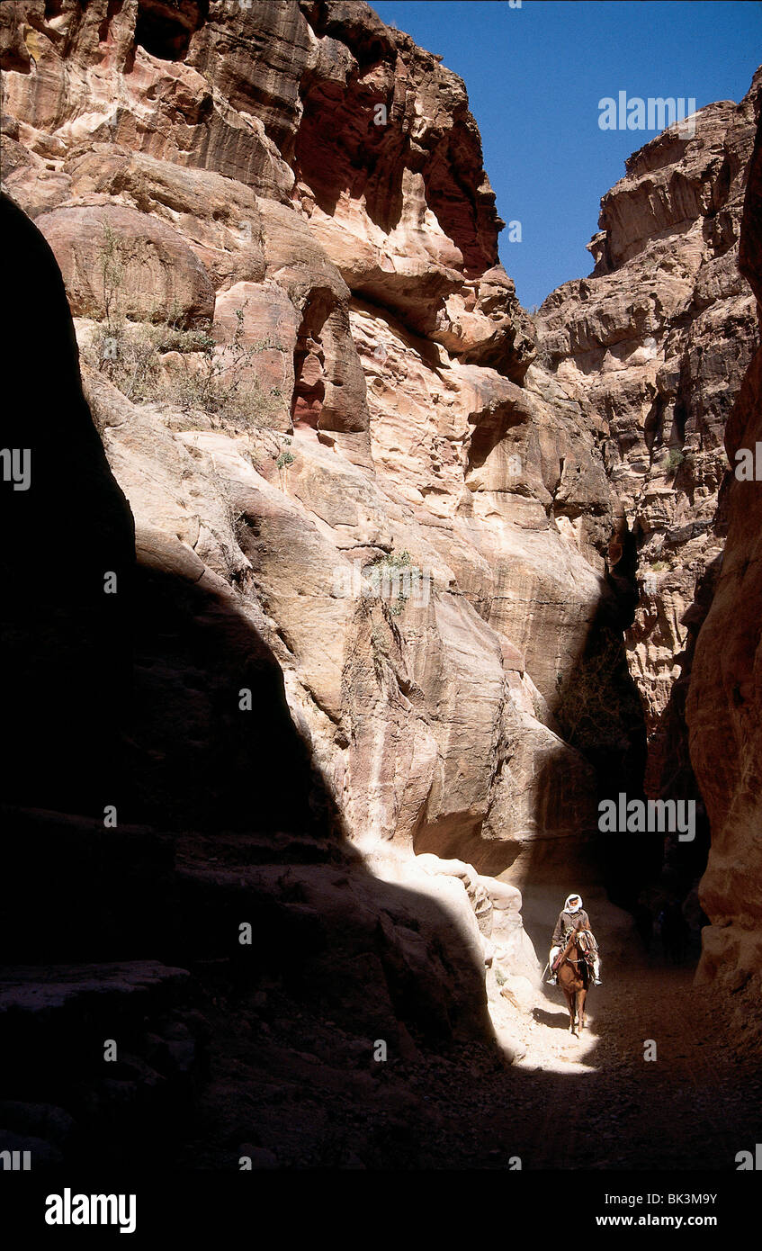 A person riding a horse in the al-Siq, a narrow canyon which leads to ...