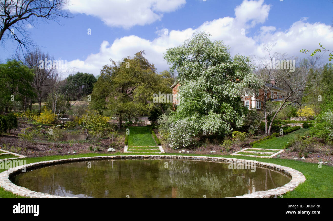 Reflection pool at a park with trees, a very blue sky and garden paths ...