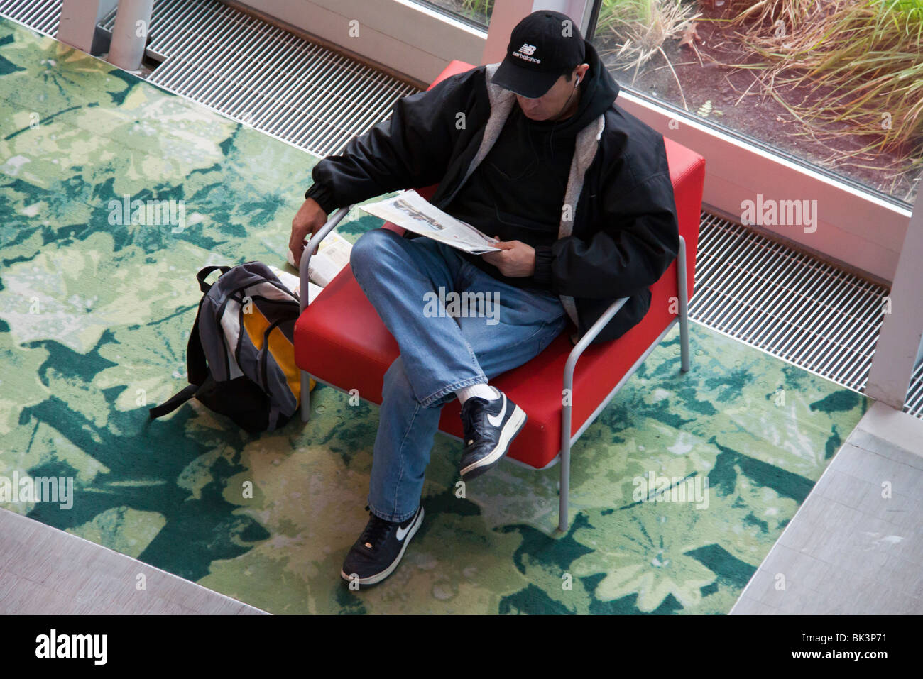 Man reading newspaper in public reading room of main branch, Seattle ...